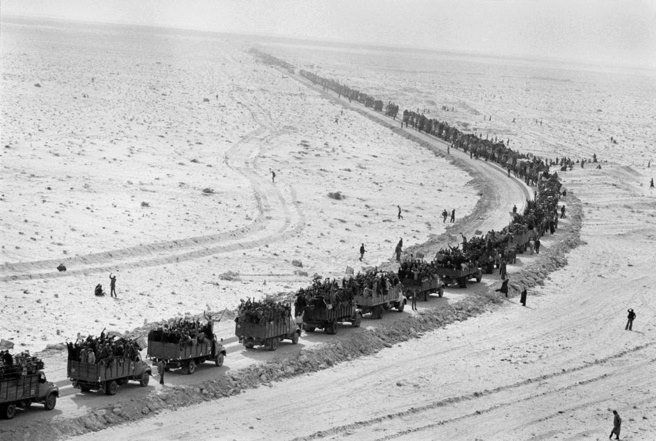 MAROCAIN PORTANT LE TABLEAU DU ROI HASSAN II MARCHE VERTE.